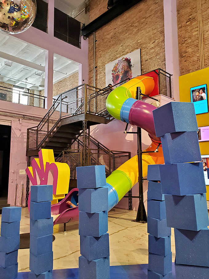 A rainbow slide proves art museums can be playgrounds too, connecting floors with a twist of childlike joy and practical fun.
