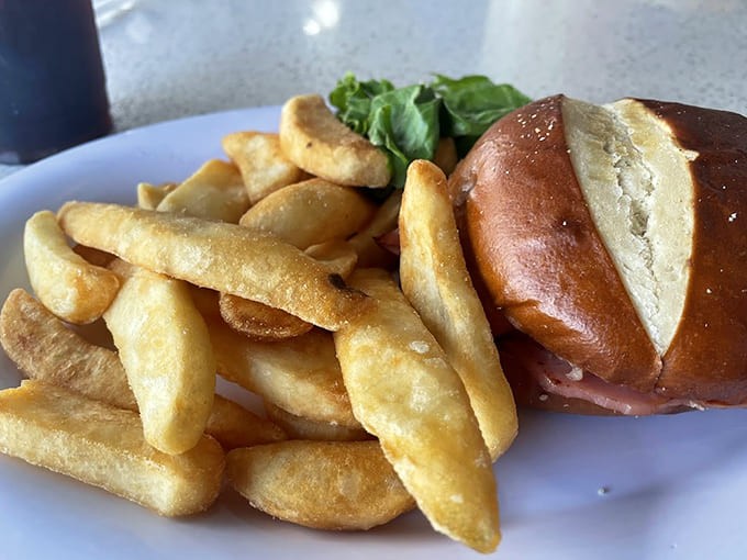 A ham sandwich that actually looks like someone cared about making it, served with fries and a pickle because some traditions just make sense.