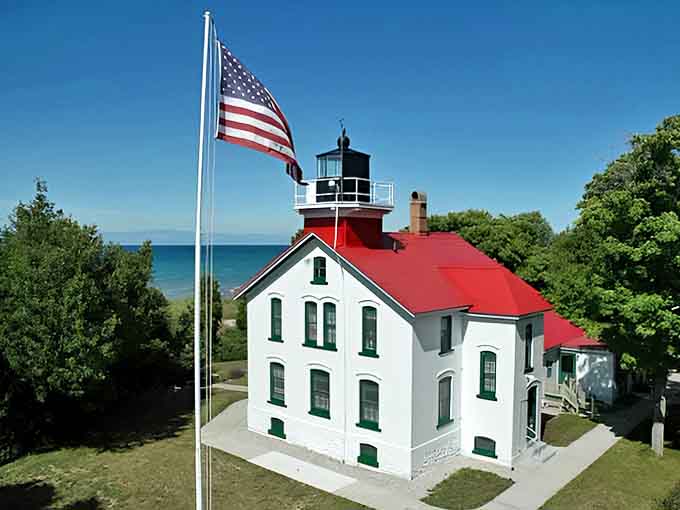 Grand Traverse Lighthouse stands sentinel, its red roof a beacon that has guided sailors home for generations.