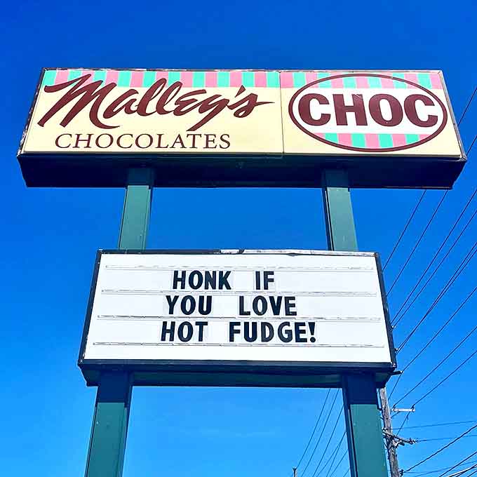 "Honk if you love hot fudge!" The roadside sign speaks to chocolate lovers everywhere, a beacon of sweetness under blue skies.