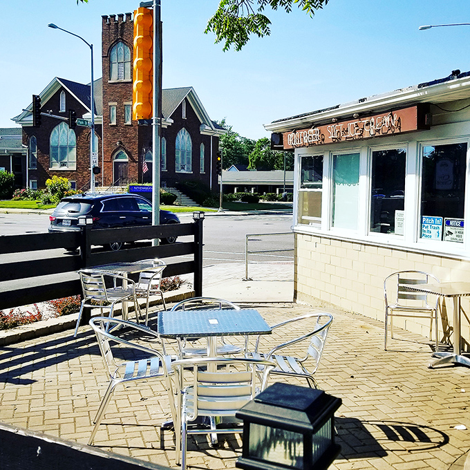 Outdoor Seating: Sun-dappled tables await hungry visitors, with the charming church backdrop adding to Hamburger Heaven's quintessential small-town American appeal.