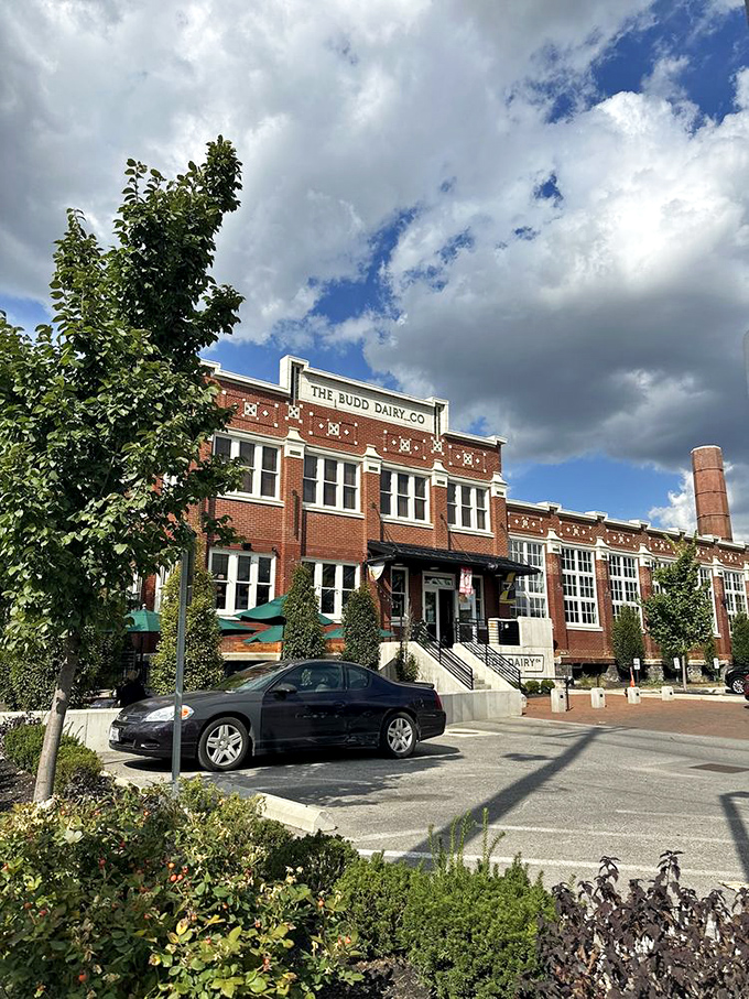 The Budd Dairy building's exterior captures both its historic past and delicious present, with thoughtful landscaping and that iconic water tower in view.