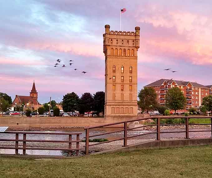 The historic Water Tower glows majestically at sunset, standing sentinel over the village like something from a European postcard.