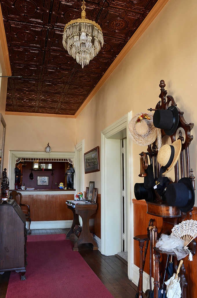 The entrance hall's ornate details and vintage hat rack set the tone for the historical journey ahead.