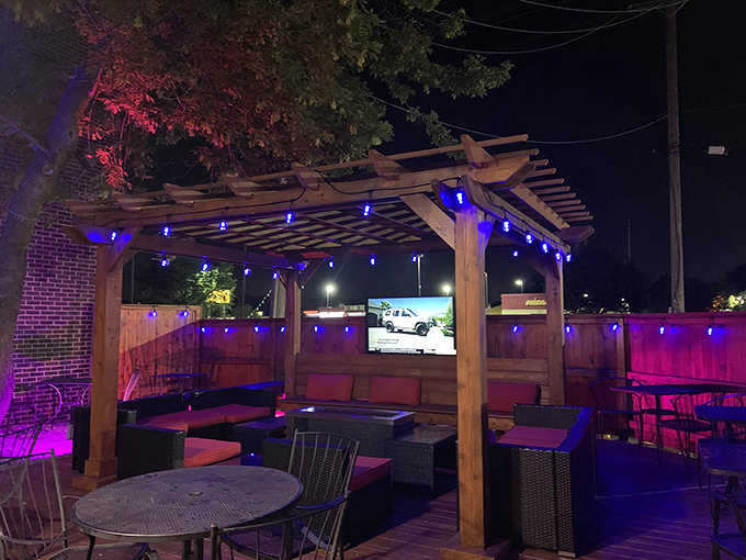 String lights twinkle above wooden pergolas, creating a magical bacon garden for those perfect Illinois summer evenings.