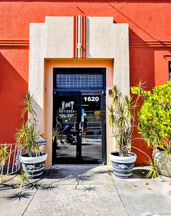 The Art Deco entrance beckons with architectural details from another era, flanked by potted plants standing guard like style sentinels.
