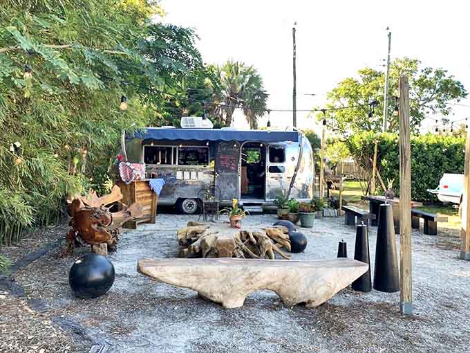 An Airstream trailer anchors this outdoor oasis, where driftwood seating and natural elements create a perfect al fresco coffee experience.
