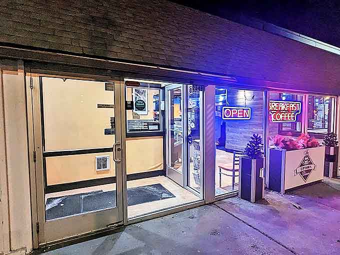 The welcoming entrance glows with neon promise in the evening light, beckoning night owls and early birds alike to the temple of waffle perfection.