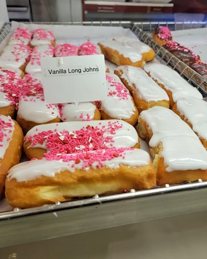 Those vanilla long johns lined up like delicious soldiers, their white icing and pink sprinkles ready to make someone's day infinitely better.