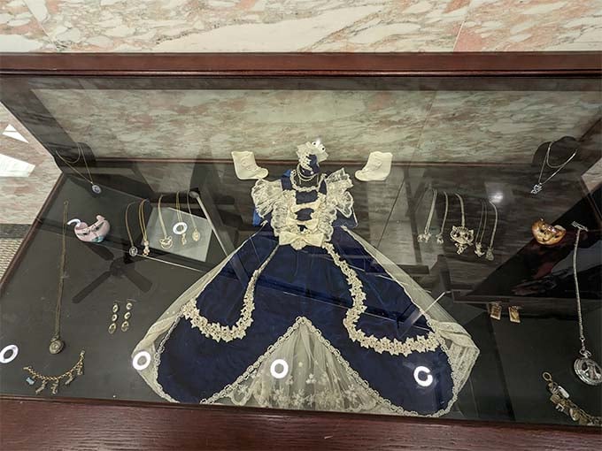 Exquisite cat-themed jewelry and a vintage dress display how feline fashion has adorned both people and their homes throughout history.