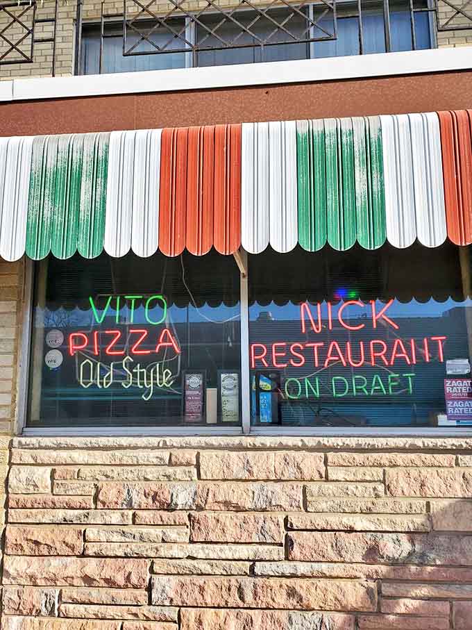 Neon signs glow in the window, a beacon for pizza pilgrims seeking the authentic thin-crust experience in a city famous for deep dish.