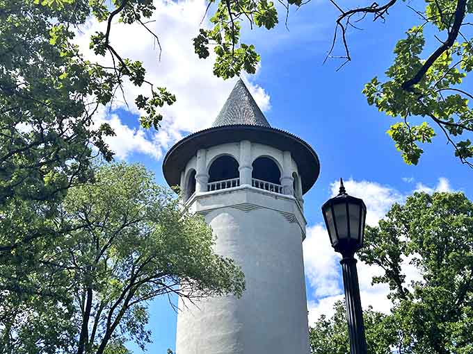 Summer sunshine highlights the Witch's Hat's fairytale charm, its green roof and white tower standing proud against azure skies.