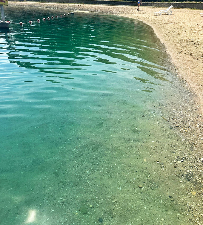 Emerald waters meet sandy shores in perfect harmony, inviting tired feet and sun-soaked bodies for a refreshing dip.