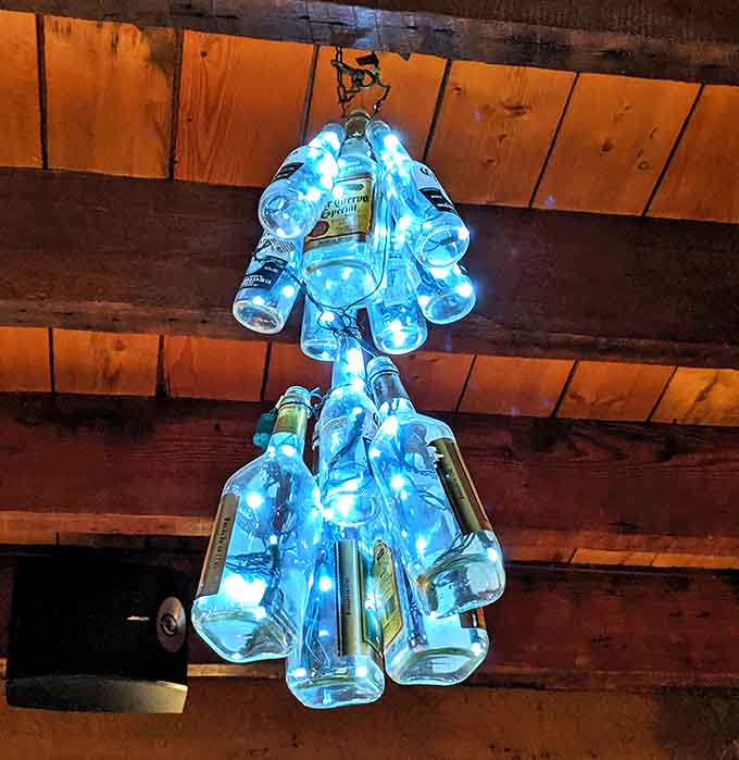 Ingenious bottle chandeliers cast a blue glow over diners &ndash; proving that in the northwoods, even the lighting fixtures tell a creative story.