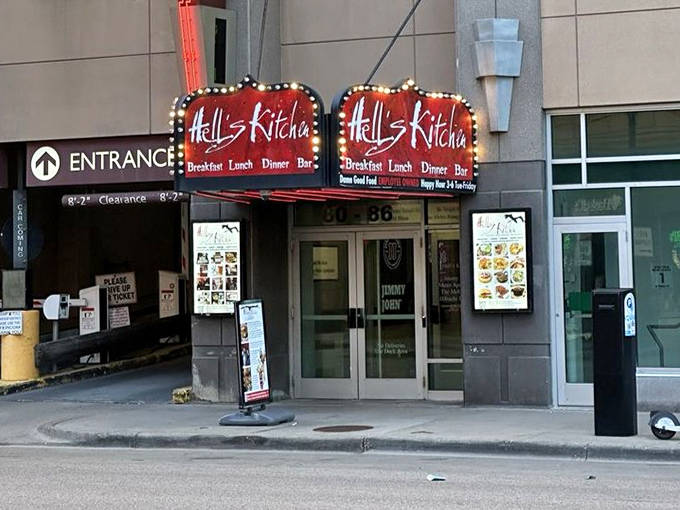 The street-level entrance might seem unassuming, but that red marquee signals the extraordinary culinary experience waiting below.