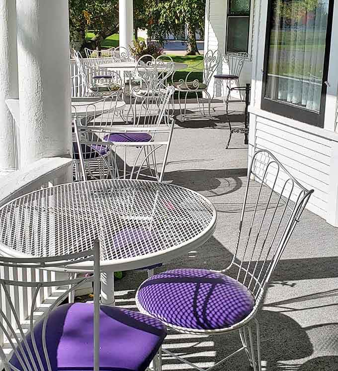 The wraparound porch offers multiple seating areas for guests to gather, proving that sometimes the best journeys happen while sitting still.
