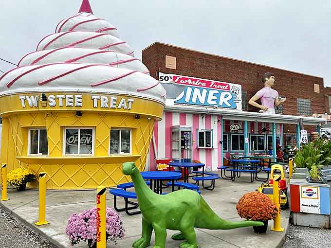 The ice cream cone building and dinosaur create a whimsical outdoor scene that makes stopping here less of a choice and more of a joyful obligation.