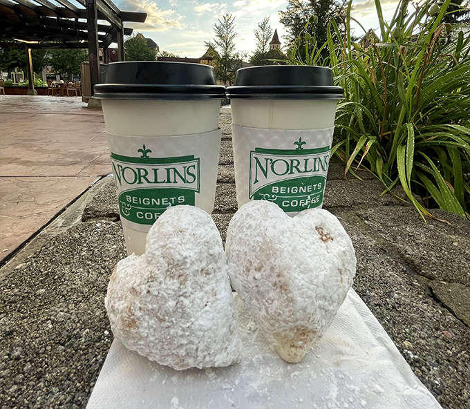 The perfect combination &ndash; heart-shaped beignets and coffee in branded cups, proving that true love does exist in culinary form.