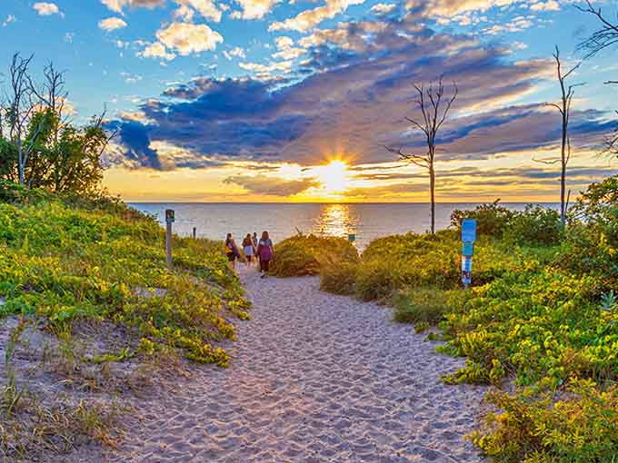 The sandy path through dune grasses leads to a spectacular view, promising that the journey's end will be worth every step.