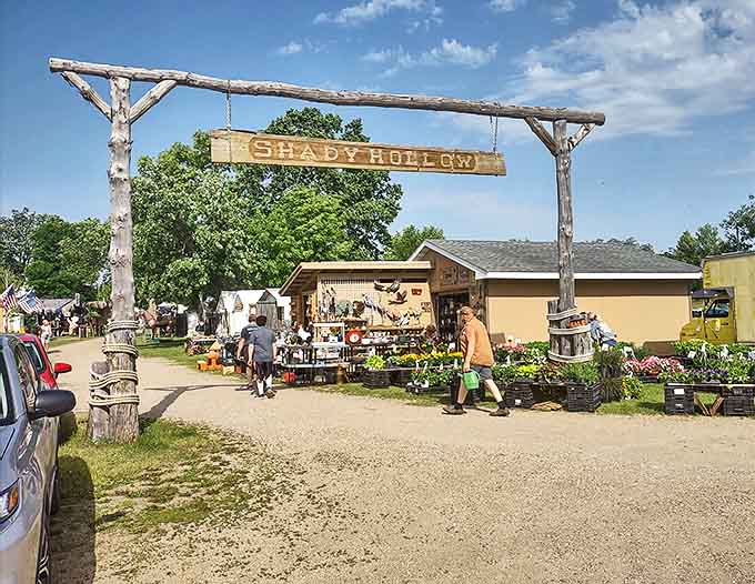 The rustic entrance arch to Shady Hollow welcomes visitors with weathered charm, promising adventures in antiquing just beyond its wooden frame.