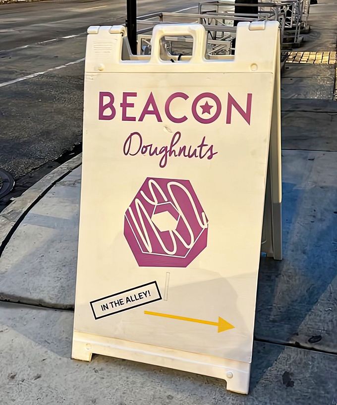 The beacon that guides hungry travelers &ndash; a simple sign pointing the way to donut nirvana hidden just around the corner.