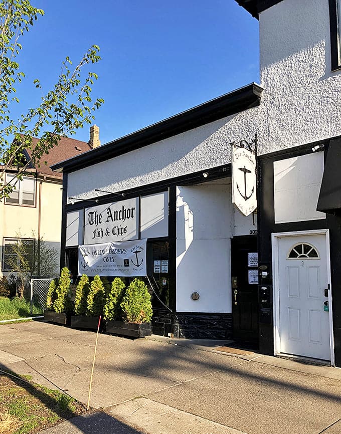The unassuming exterior of The Anchor Fish & Chips hides culinary treasures within its white walls and classic signage.