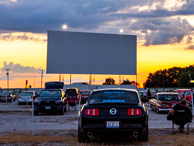 Sunset at the drive-in creates pure movie magic as cars line up facing the massive screen, ready for nightfall to bring stories to life.