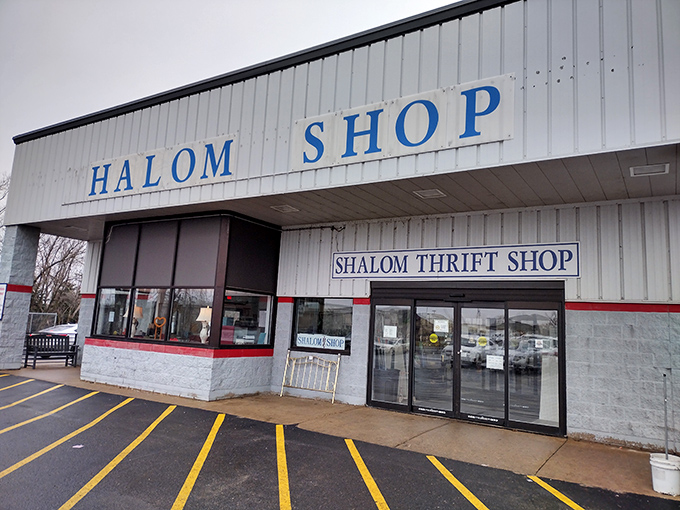 The welcoming facade of Shalom Thrift Shop in Cambridge invites bargain hunters with its bright blue signage and spacious parking lot.