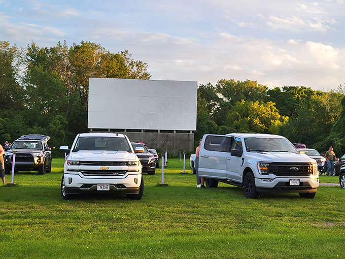 Pickup trucks and SUVs claim their spots at Big Sky Twin Drive-In, where modern vehicles meet classic entertainment under Wisconsin's open skies.