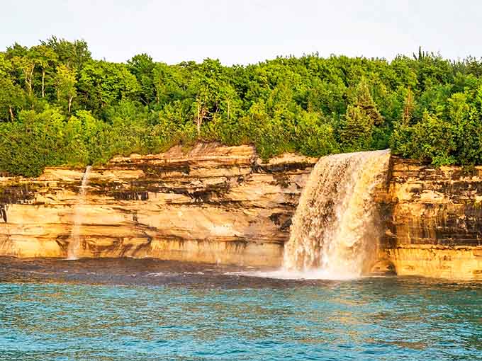 Seventy feet of pure liquid drama cascading down striped sandstone cliffs, because Mother Nature doesn't believe in doing anything halfway.