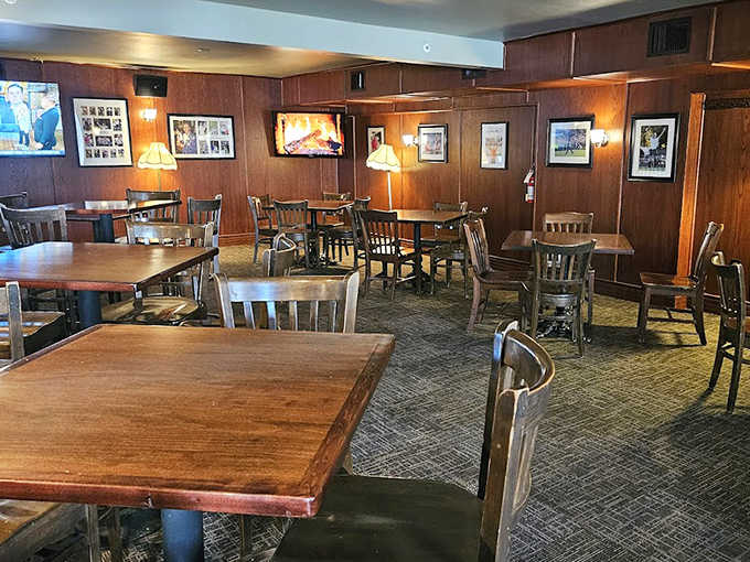 Warm wood paneling and soft lighting create the cozy atmosphere of a traditional British pub, inviting guests to settle in for the evening.