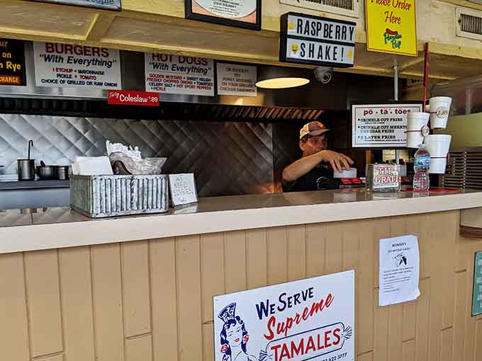 Behind that order window, magic happens daily as burgers sizzle and cheese melts into pools of golden perfection for hungry crowds.