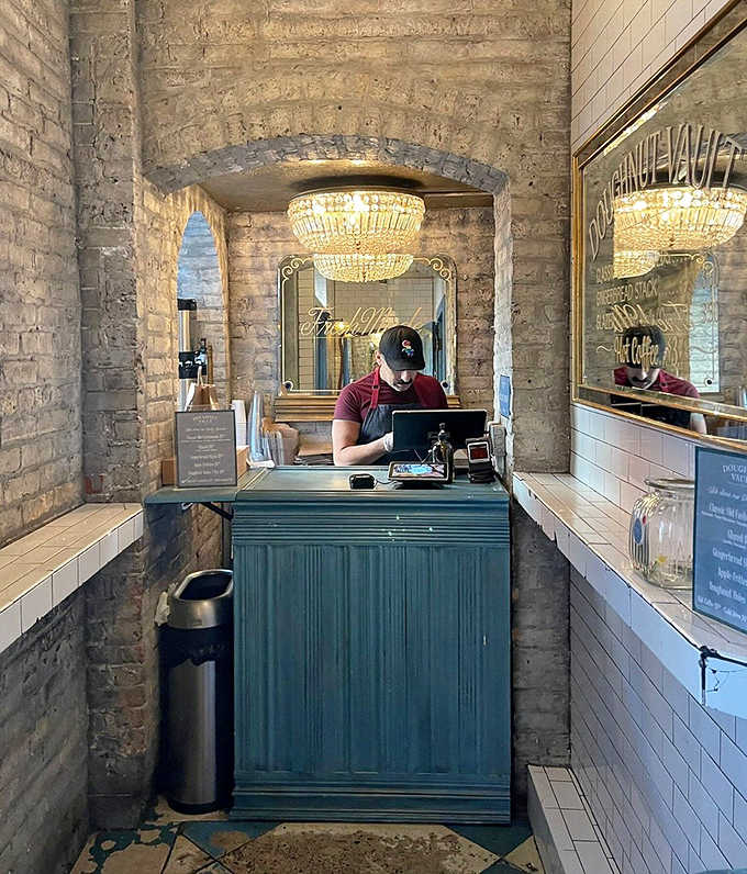 Exposed brick walls and a crystal chandelier create an unexpected elegance at the counter, where donut dreams come true one transaction at a time.