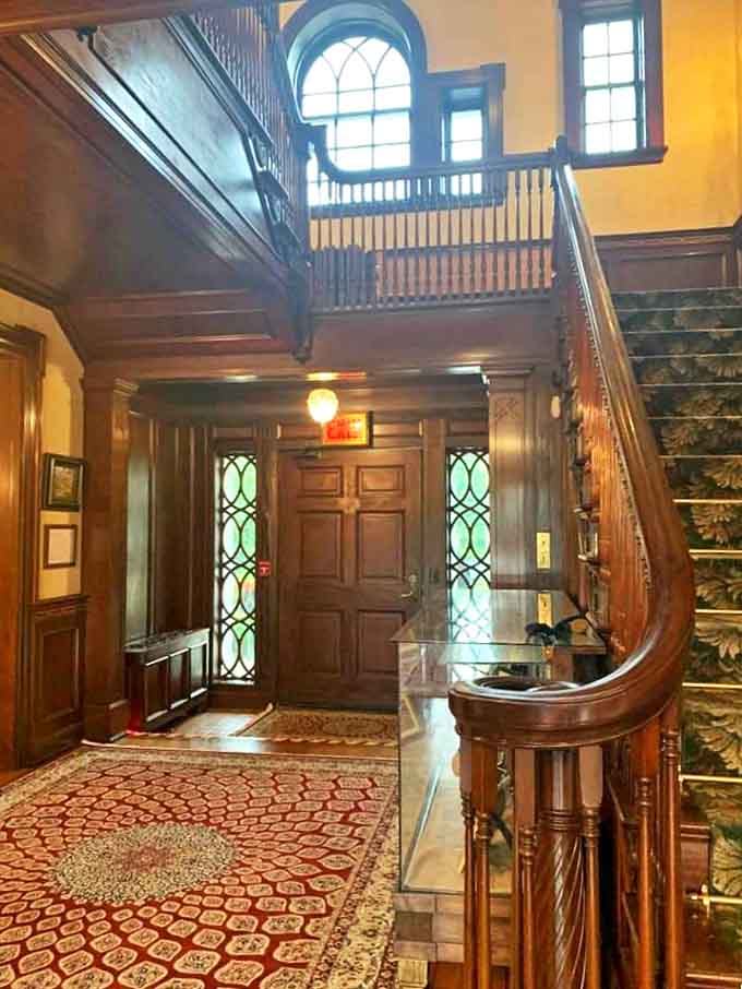 Polished wood curves gracefully upward, inviting visitors to ascend into history. Each step whispers tales of elegant parties and midnight wanderings.