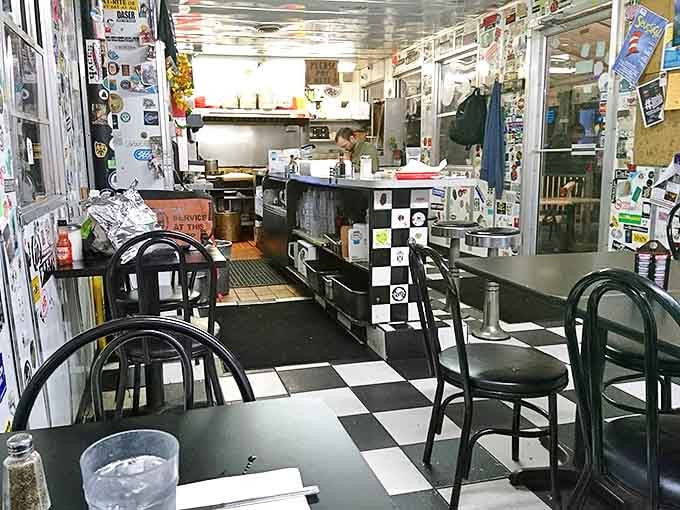 Inside, the classic black and white checkered floor contrasts with walls absolutely plastered with stickers &ndash; decades of Ann Arbor history on display.