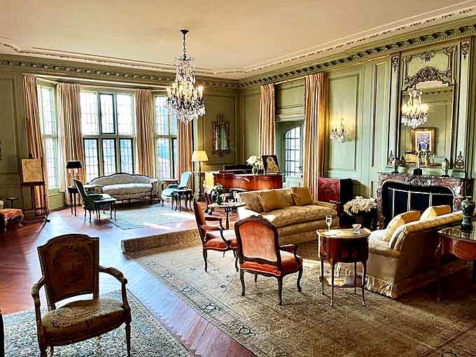 Elegant green walls, crystal chandeliers, and period furniture create a living room that's both museum-worthy and surprisingly inviting.