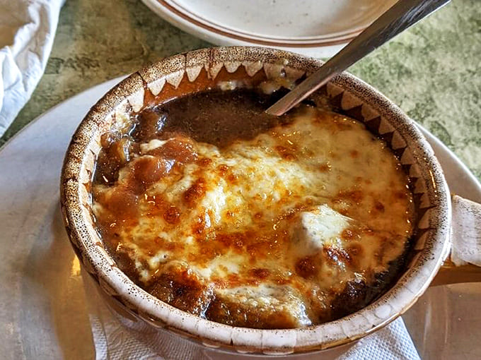 Bubbling perfection in a crock &ndash; the legendary French Onion Soup arrives with a golden cheese canopy that's worth the inevitable roof-of-mouth burn.