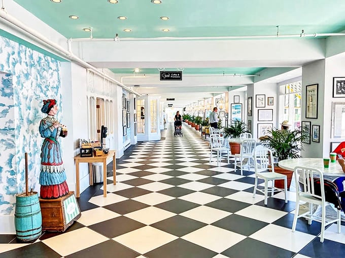Black and white checkered floors lead the eye down this mint-hued corridor, where history whispers from every corner and afternoon light creates a peaceful sanctuary.