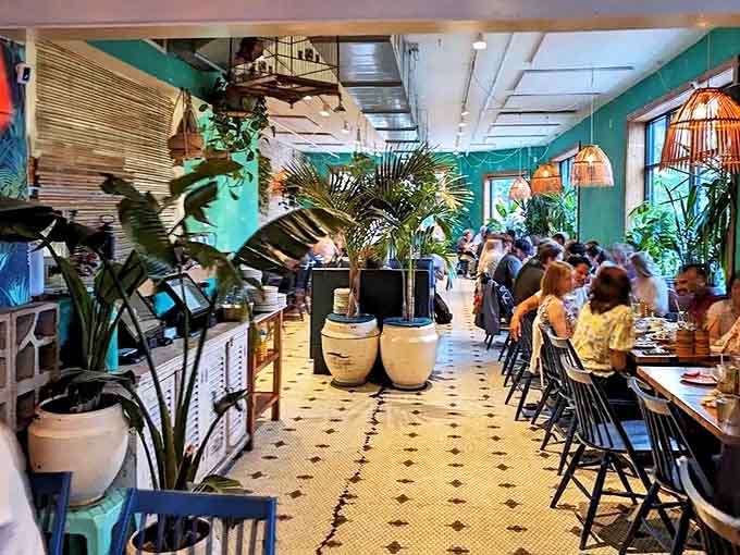 Step inside to discover a lush interior where hanging plants, turquoise walls, and vintage-inspired tiles transport you straight to Southeast Asia.