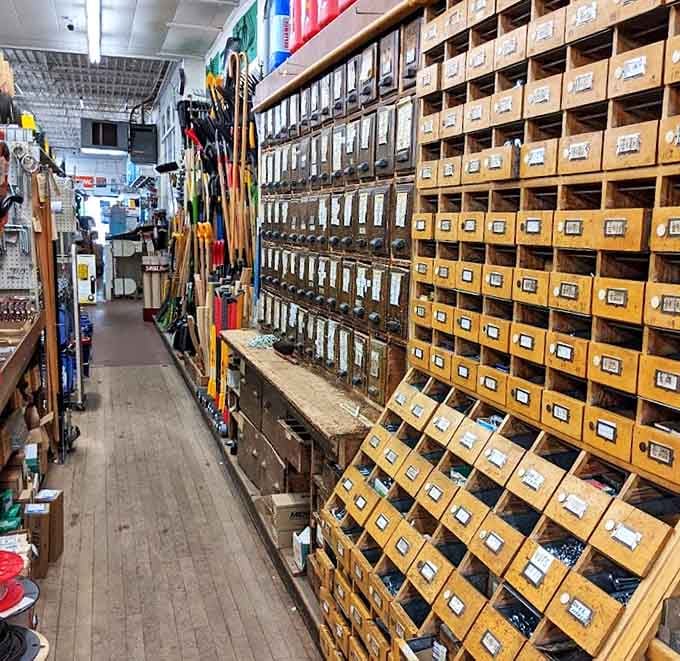 Narrow aisles lined with wooden drawers create a treasure hunter's paradise, where every tiny compartment holds the exact solution to your hardware needs.