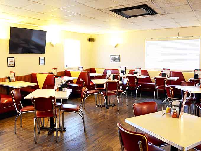 Classic red vinyl booths and retro diner chairs create an authentic atmosphere where conversations flow as freely as the beer taps.