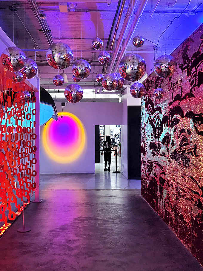 Neon dreams come alive in this corridor where disco balls hang from the ceiling and vibrant purples clash with reds in electric harmony.