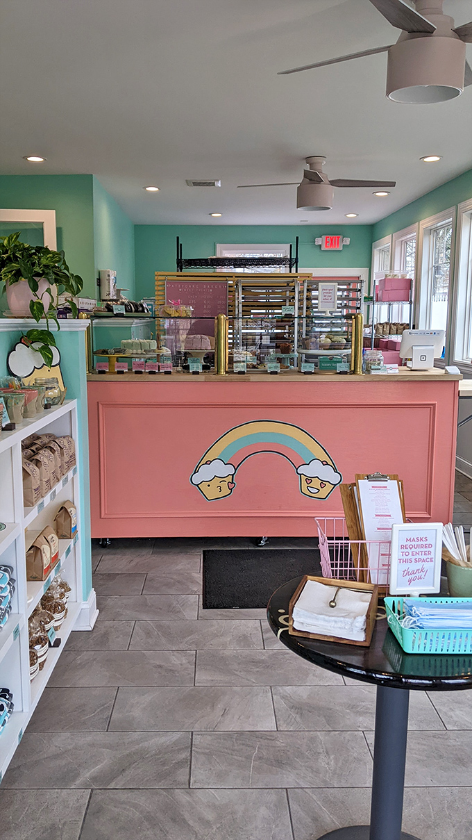 Mint walls and a pink counter create the perfect backdrop for sugar-fueled dreams, while the smiling cupcake rainbow logo promises deliciousness ahead.