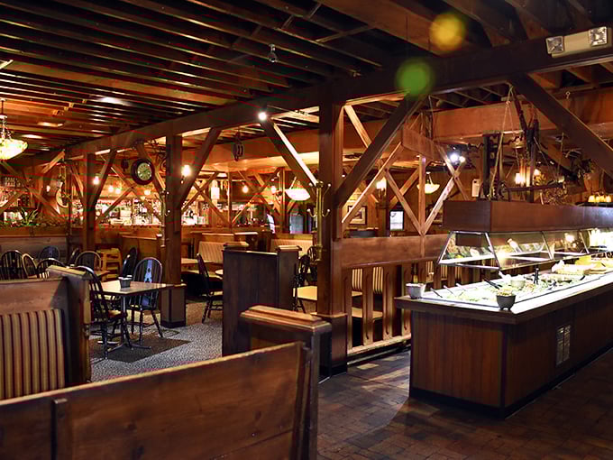 Exposed wooden beams create a cathedral-like atmosphere inside this former dairy barn, where rustic charm meets dining comfort in perfect farmhouse harmony.