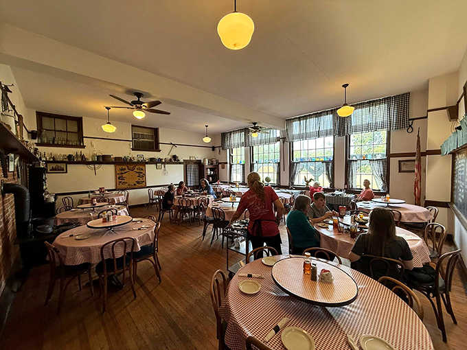 Checkered tablecloths and vintage lighting transform the former classroom into a dining sanctuary where comfort food reigns supreme.