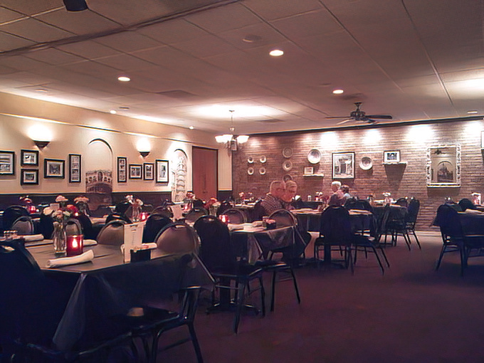 Interior: Warm lighting, brick walls adorned with photographs, and comfortable seating create that perfect "welcome home" feeling that keeps generations of diners returning.