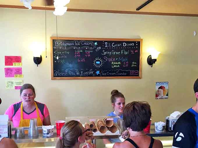 Inside, the chalkboard menu promises frozen treasures while friendly staff prepare to scoop up happiness by the cone or cup.