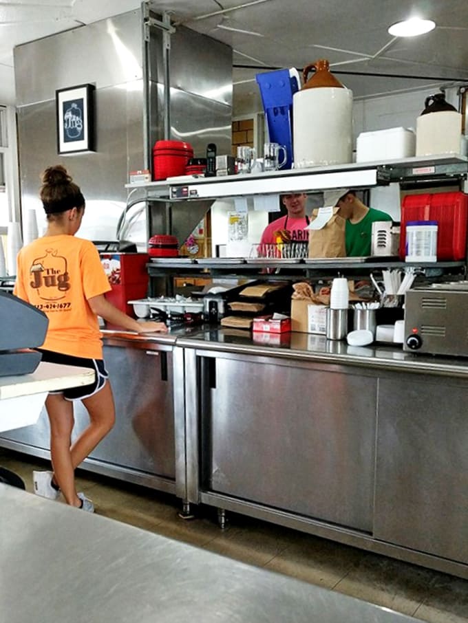 Stainless steel gleams as staff in bright orange shirts orchestrate the burger ballet &ndash; efficiency with a side of nostalgia.