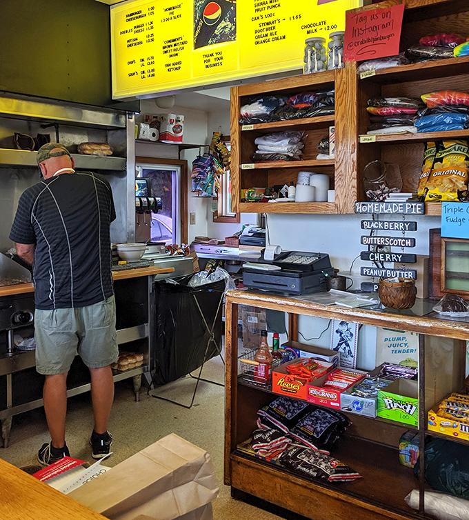 Behind the counter, burger magic happens with methodical precision. Those homemade pie options on the right? Pure Midwestern temptation.