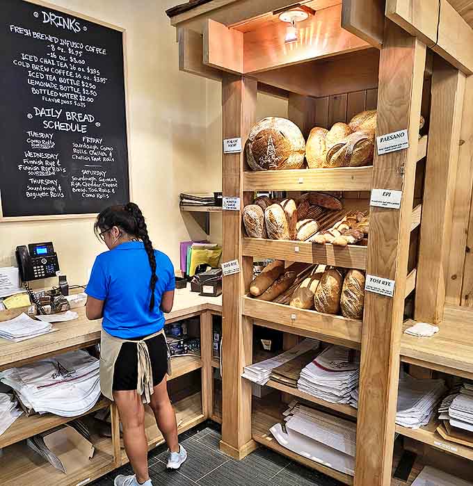Interior: Behind the counter, fresh-baked treasures await while a daily bread schedule promises carb-lovers a reason to return tomorrow.